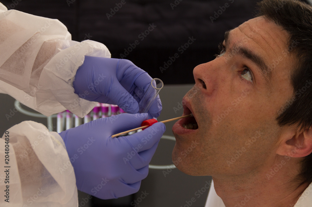 Taking a DNA sample. DNA swab of saliva taken from senior man Stock ...