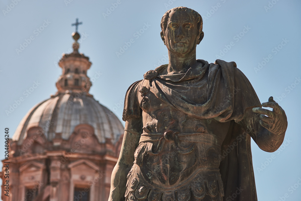 Rome, Bronze statue of emperor Julius Caesar, in the background the ...