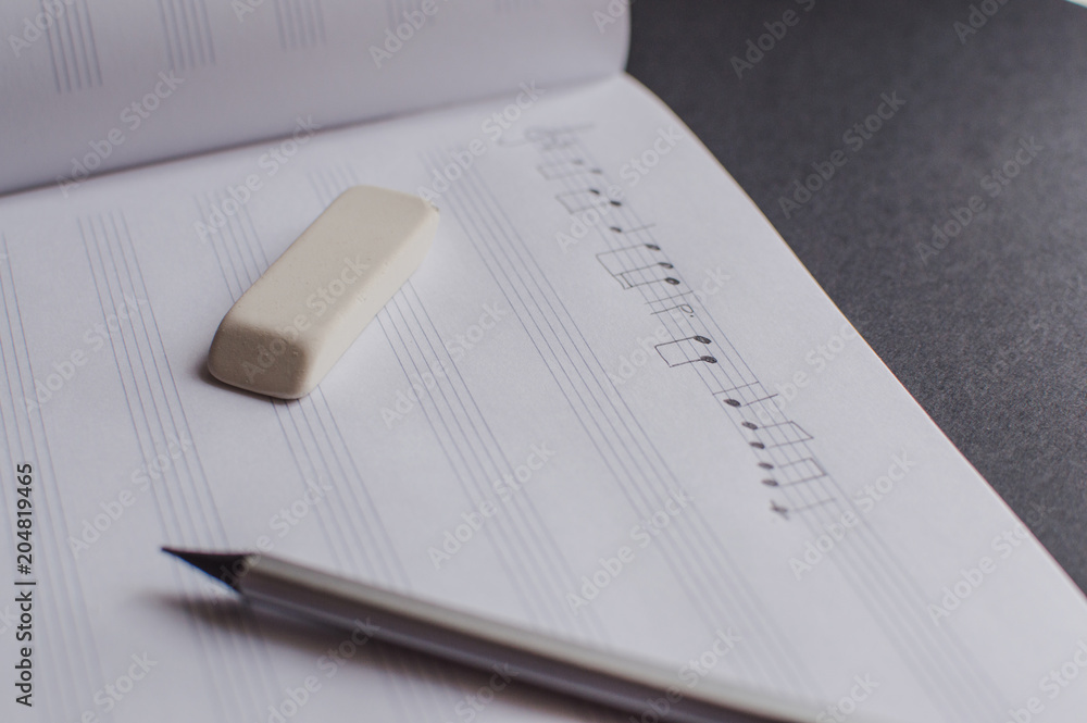 Side view of the pencil, eyeglasses and eraser laying near to the sheet ...