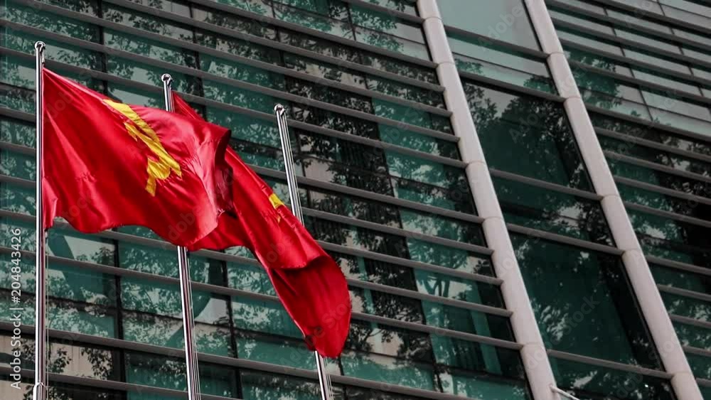 The red flag with communist symbols of a sickle and a hammer flying by ...