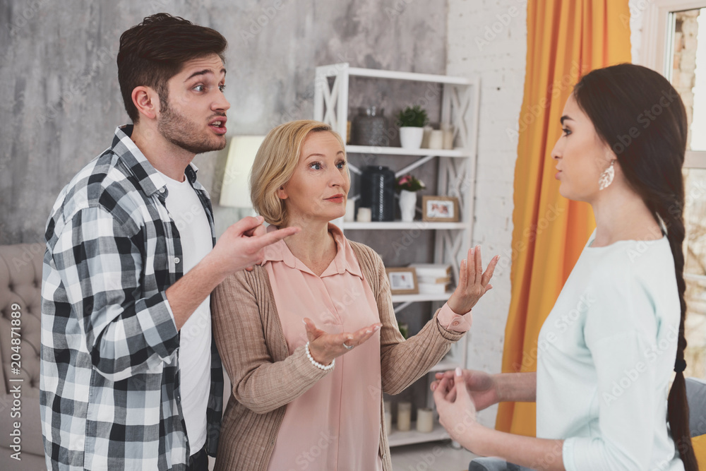 Family argument. Unpleasant aged woman standing near her son while ...