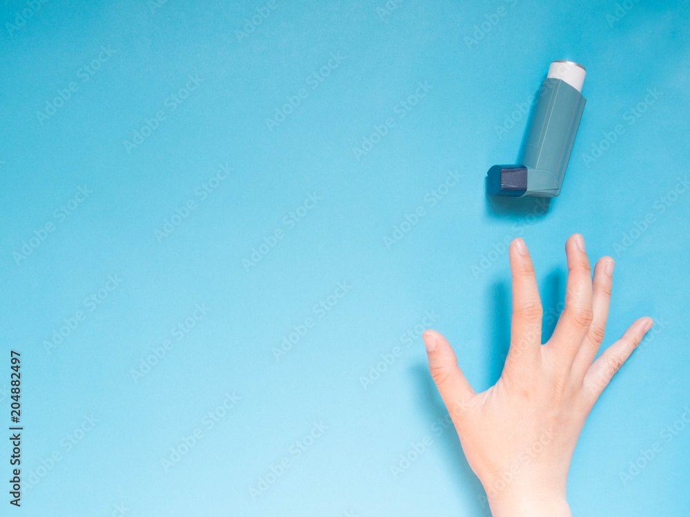 Asthma and COPD disease concept. Young female hand trying to reach blue ...
