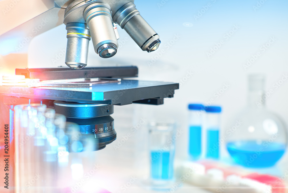 Scientific background with closeup on light microscope and laboratory ...