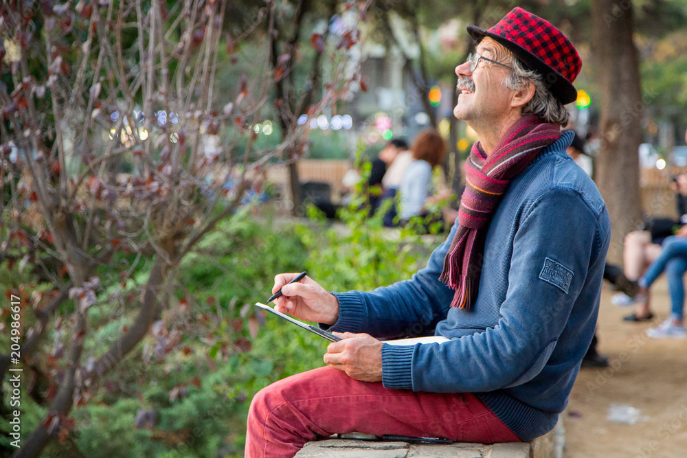 Artist sketching in notebook outdoor, free space. Attractive man ...