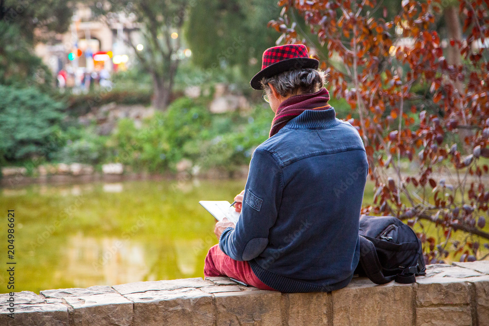 Artist sketching in notebook outdoor, free space. Attractive man ...