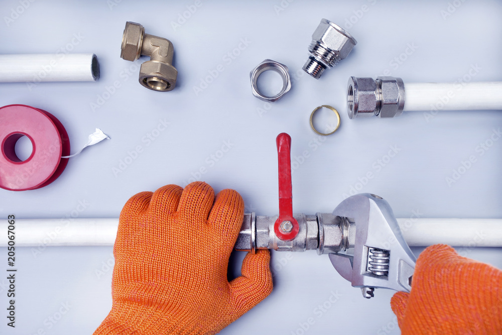 Professional male plumber of tightening the screw with a spanner.Repair ...