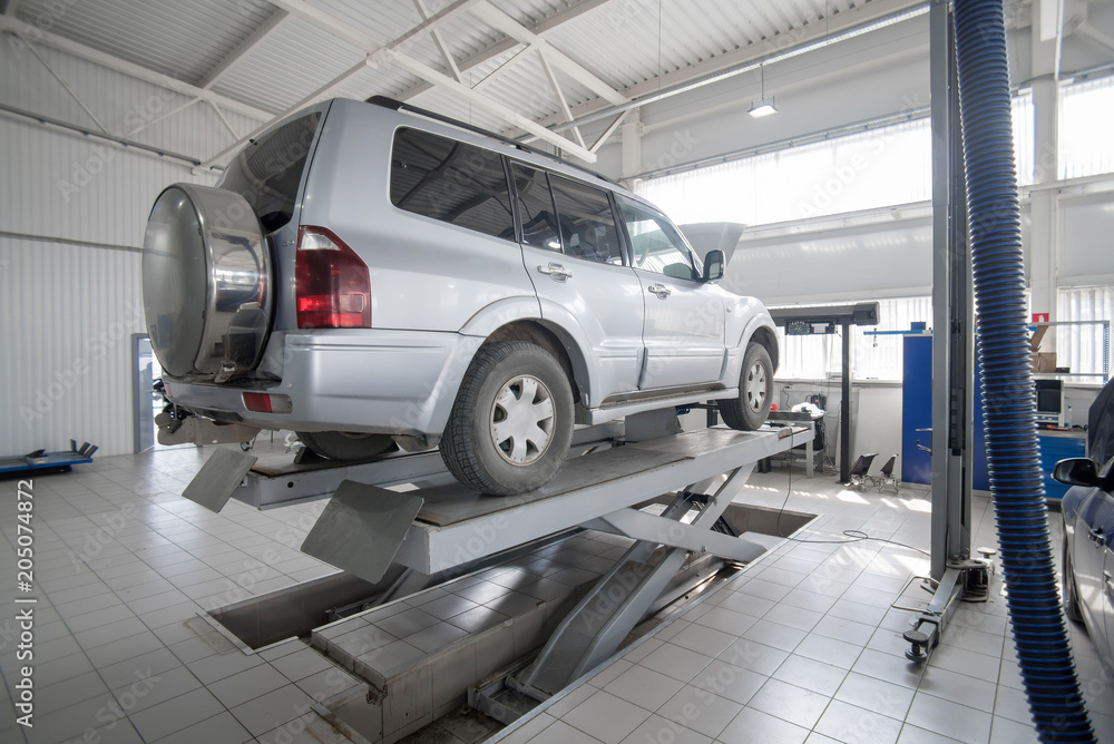 Car on a wheel alignment lift in auto service. Diagnosis of the chassis ...