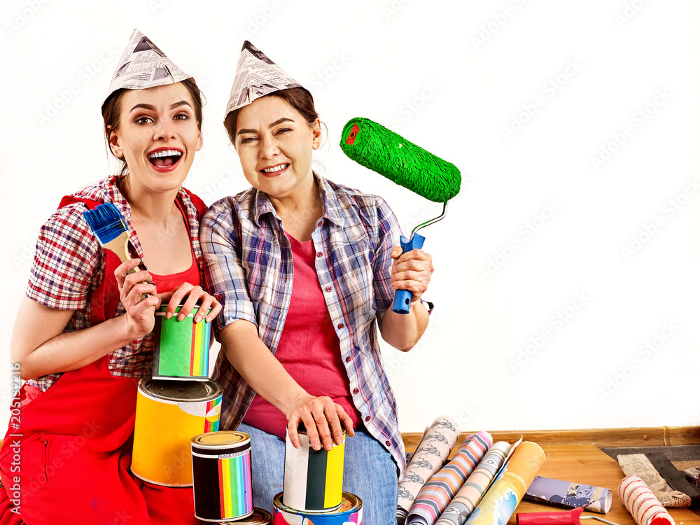 Repair home women holding color guide for wallpaper. Elderly mother and ...