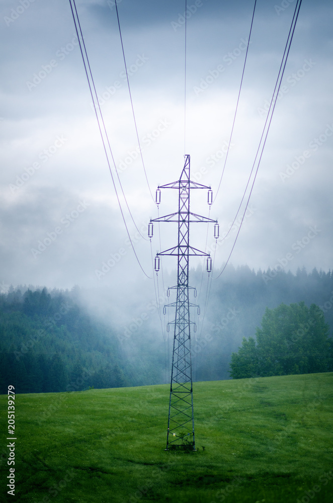 High voltage towers in a middle of forests and meadow. Electricity ...