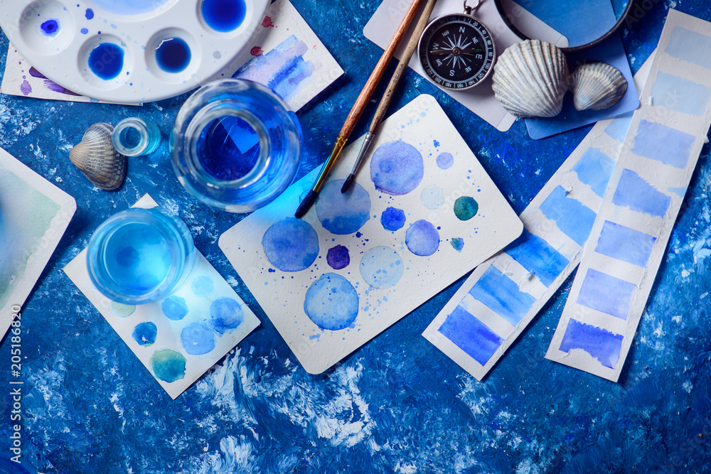 Creative artist workplace with marine watercolor, palettes, swatches ...