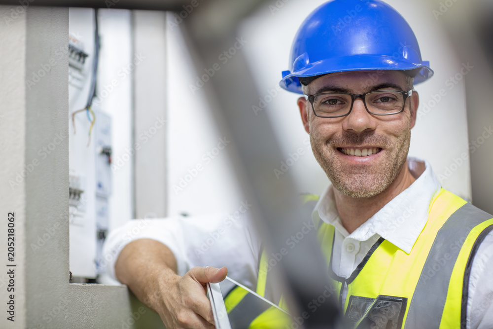 Portrait of smiling electrician at fuse box Stock-Foto | Adobe Stock
