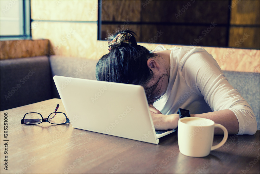 Asian charming beautiful girl worker sleeping with laptop and a cup of ...