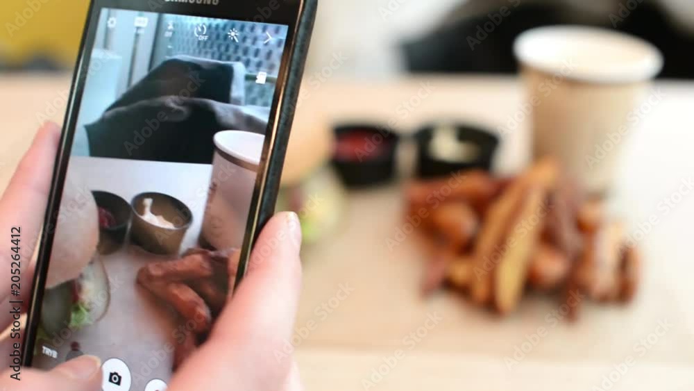 Trendy Woman In A Restaurant Make Photo Of Food With Mobile Phone ...