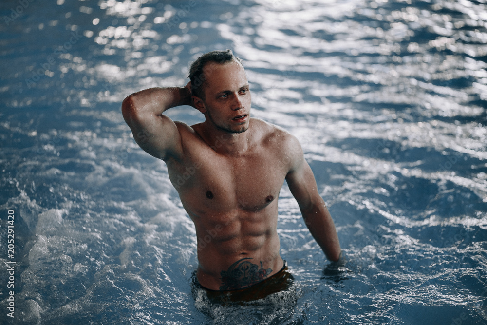 Sexy male model posing in swimming pool Stock Photo | Adobe Stock