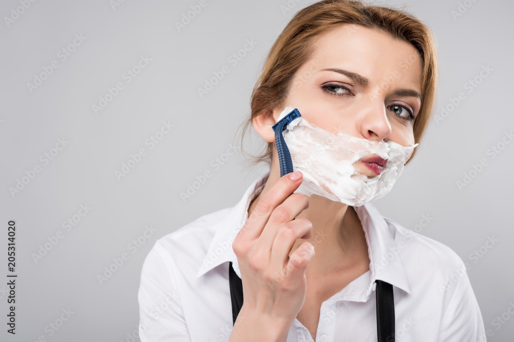 businesswoman shaving face her face, isolated on grey, feminism concept ...