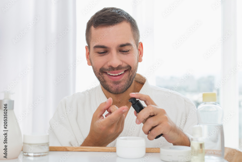 Cleaning procedure. Joyful nice man applying cleansing gel while ...