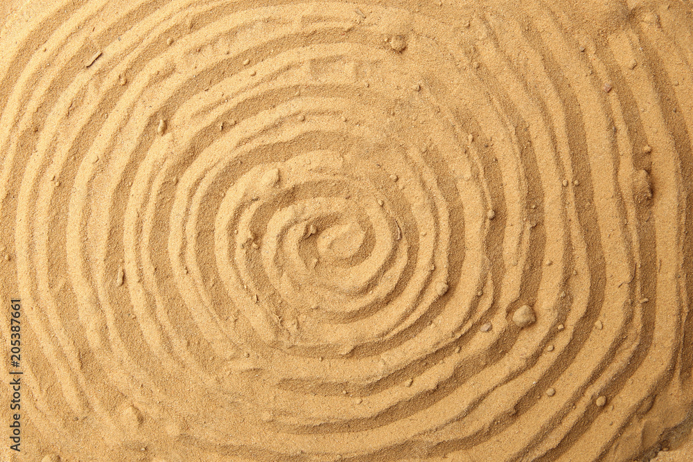 Spiral drawing on beach sand background. Spiral pattern on golden sand ...