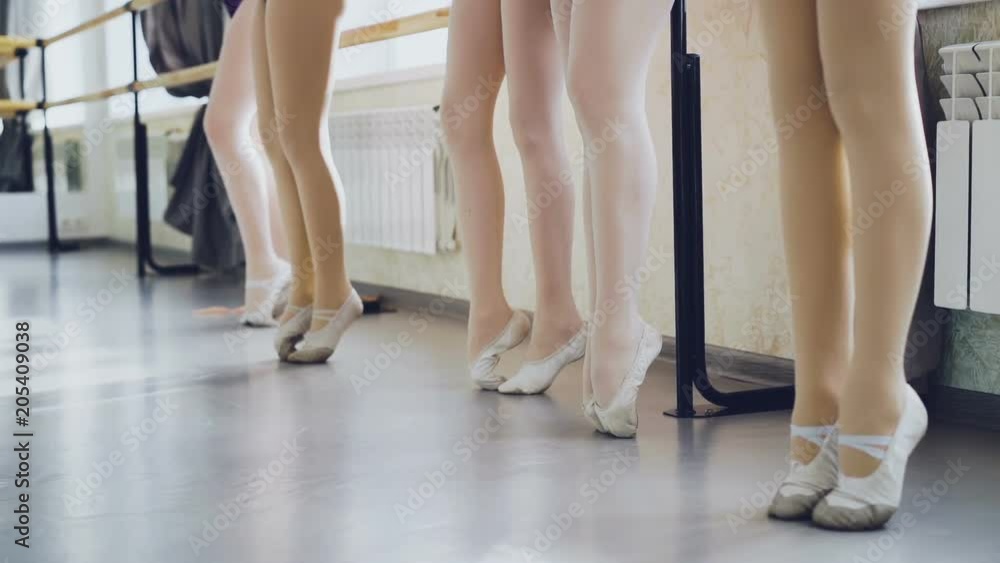 Slow motion of slim women's legs in pointe shoes standing on tiptoes ...