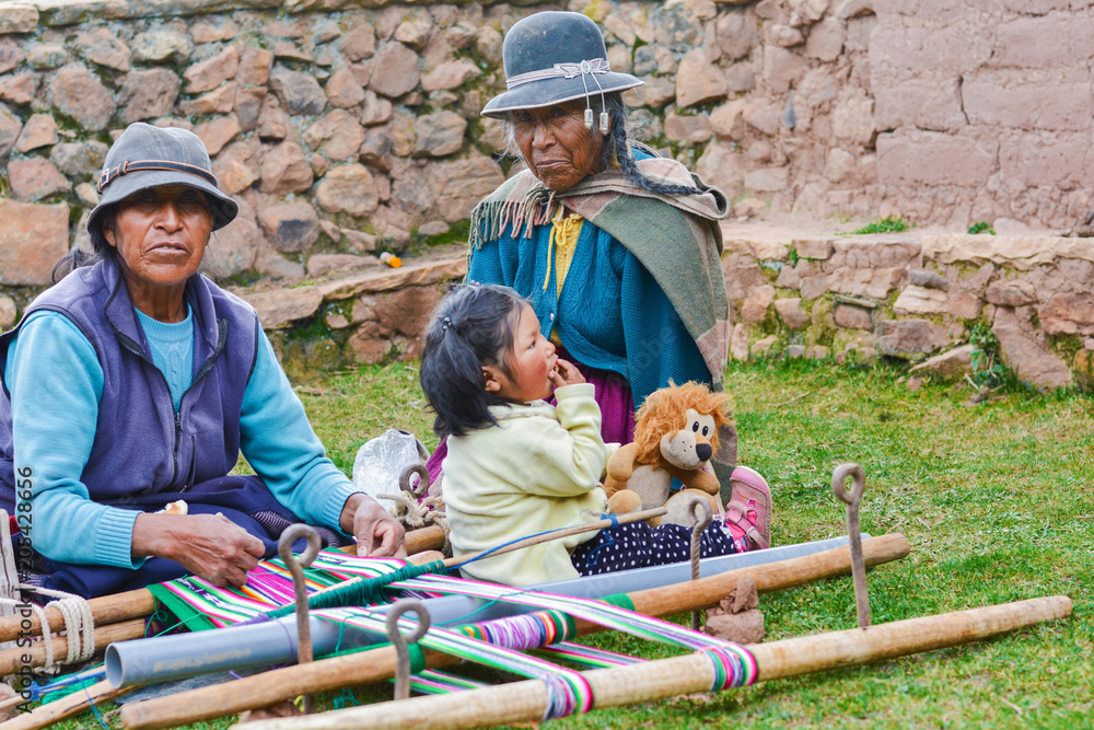 Three generations of native american women in the countryside weaving ...