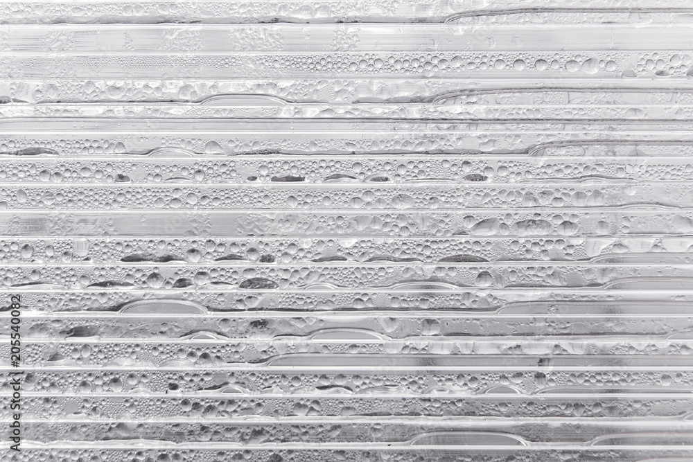 Water drop on reflective clear plastic wrap. The texture of the drops ...