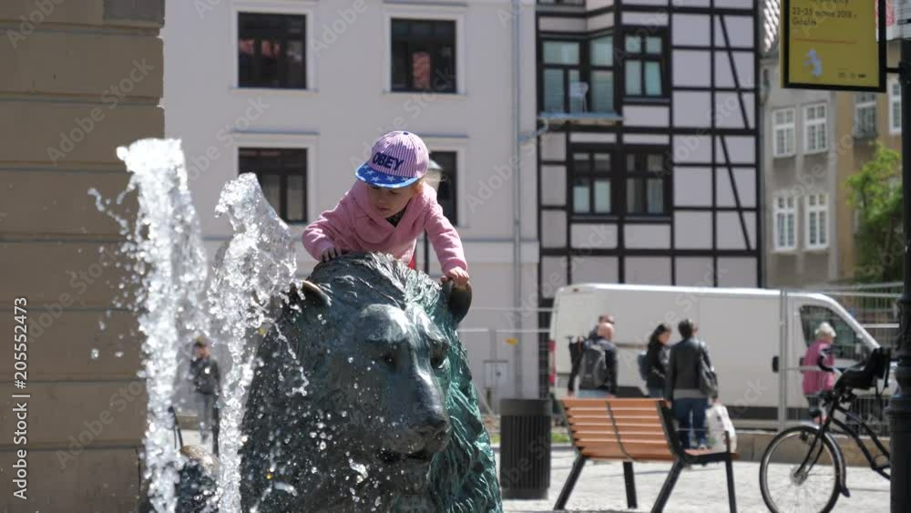Gdansk Poland city center child girl play climb the bronze statue of ...