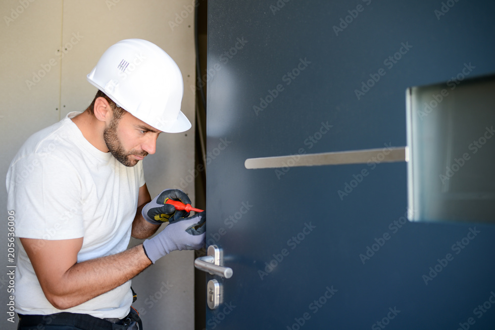 handsome young man installing a door in a new house construction site ...