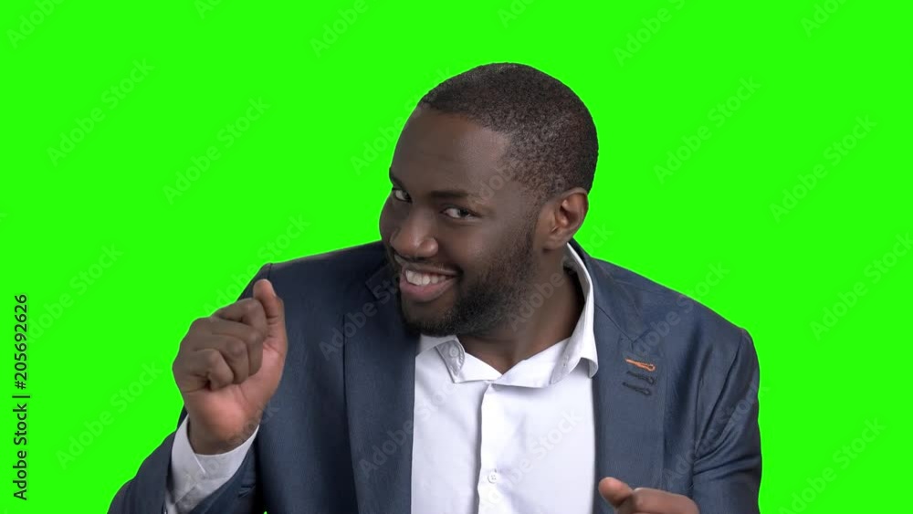 Playful dark-skinned businessman on green screen. Young cheerful afro ...