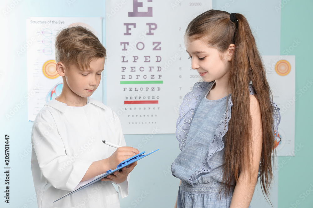 Cute little children playing doctor and patient in ophthalmologist ...