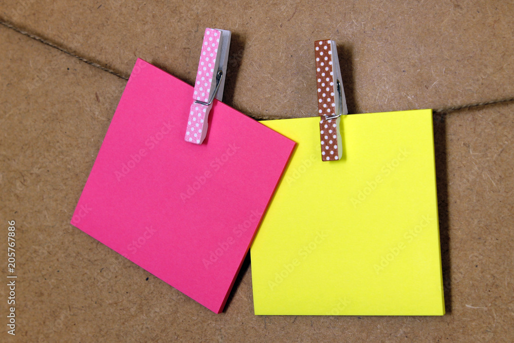 Hoja de papel de color verde y amarillo (posit), sujeto con pinzas de ...