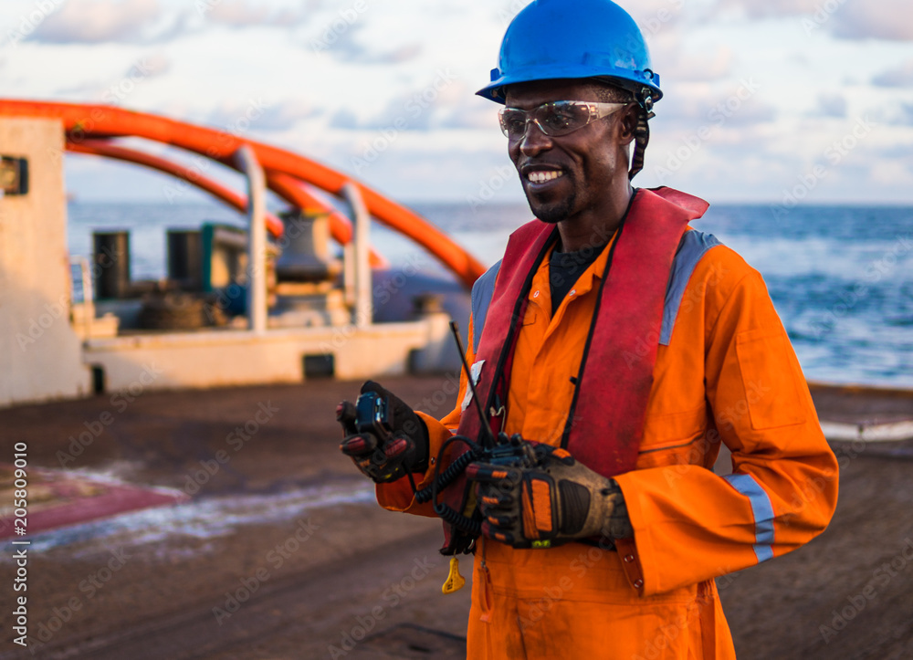 Seaman AB or Bosun on deck of vessel or ship , wearing PPE personal ...