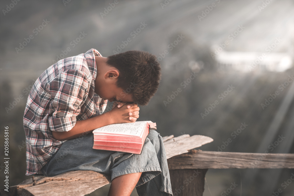 boy praying to God. Stock Photo | Adobe Stock