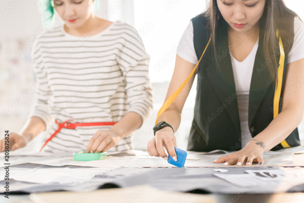 Mid section portrait of two creative female tailors drawing sketches ...