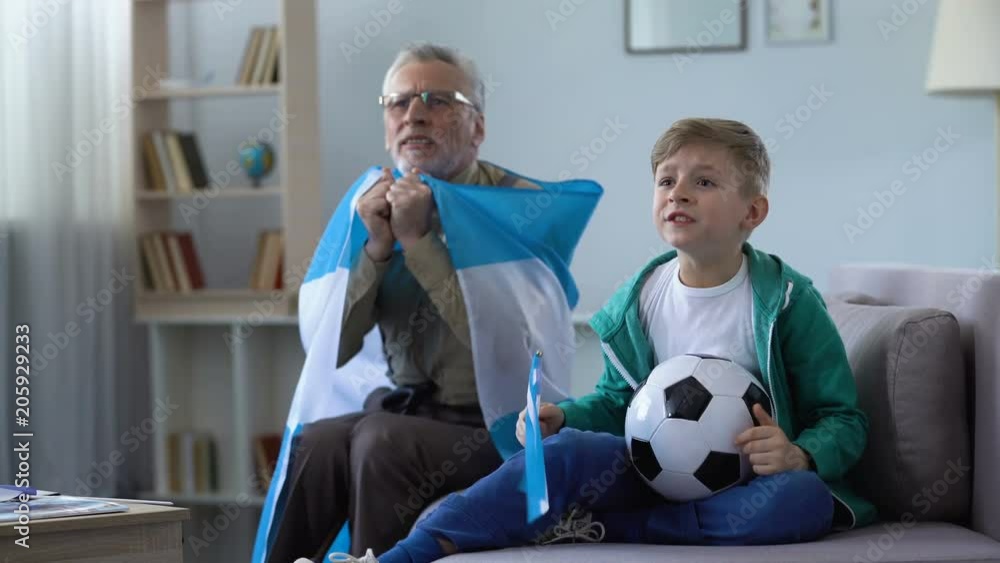 Grandpa waving Argentina flags together with grandson, watching ...