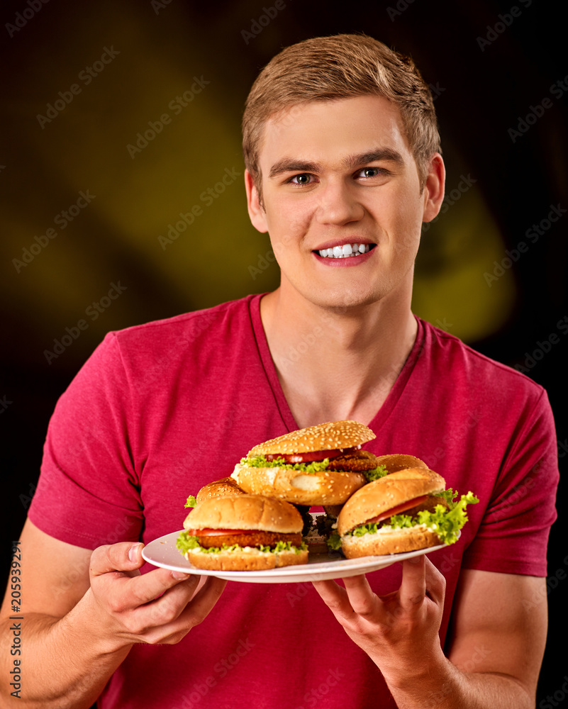 Man eating french fries and hamburger with pizza. Portrait of student ...