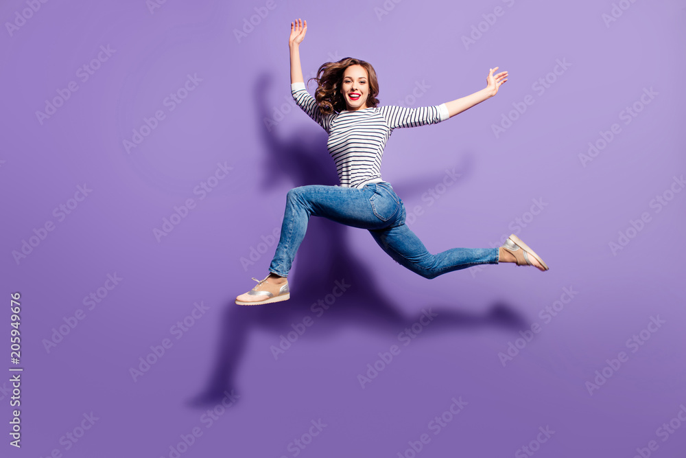 Portrait of crazy foolish girl jumping over in the air looking at ...