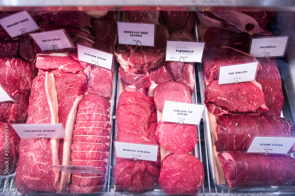 Dark red raw fatty meat boneless with fat beef steaks, in store display ...