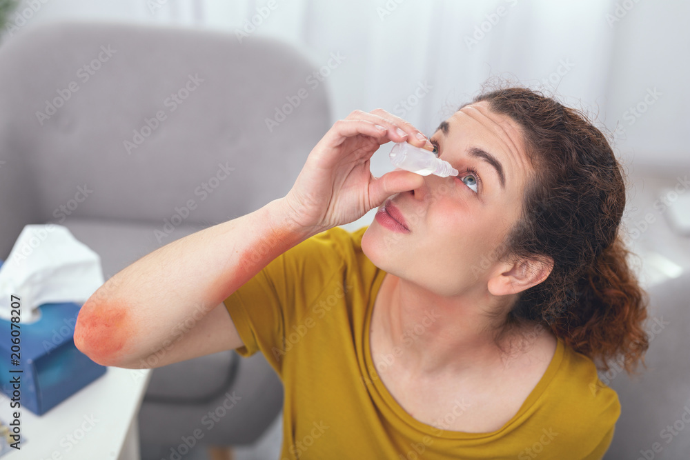 Self medicating. Young sicl looking woman trying to perform self ...