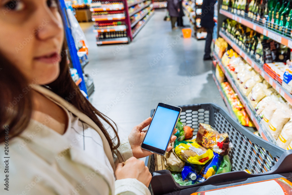 woman hold phone with white screen while make grocery shopping Stock ...
