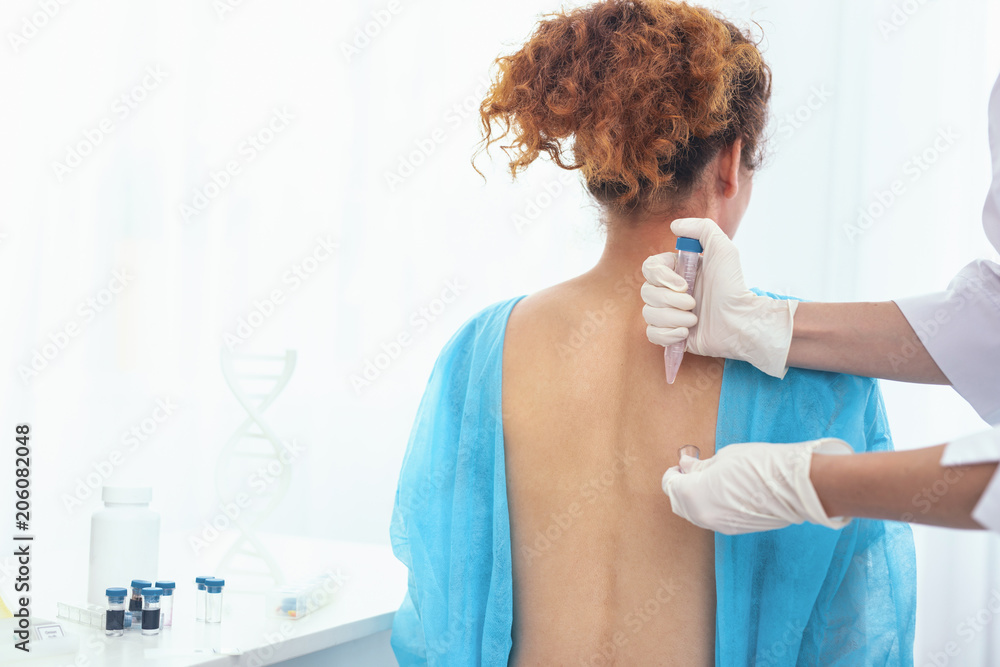 Curing dermatitis. Young woman patient standing in doctors laboratory ...
