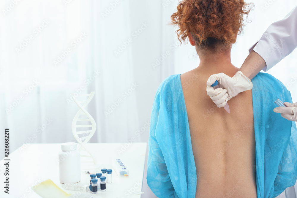 Finishing touch. Young woman standing patiently in an examination room ...