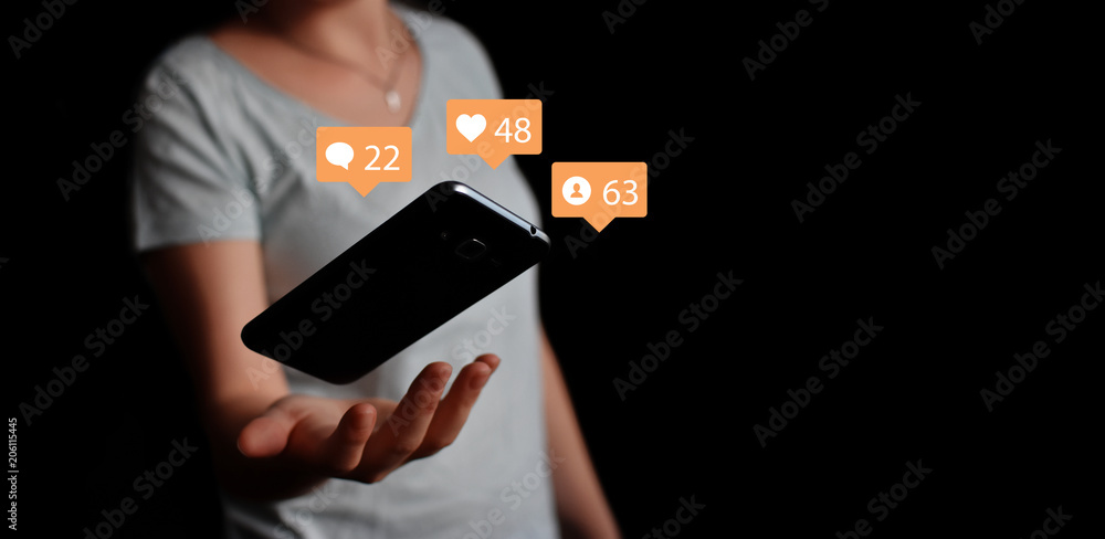 Phone floating above female person hand surrounded with social media ...