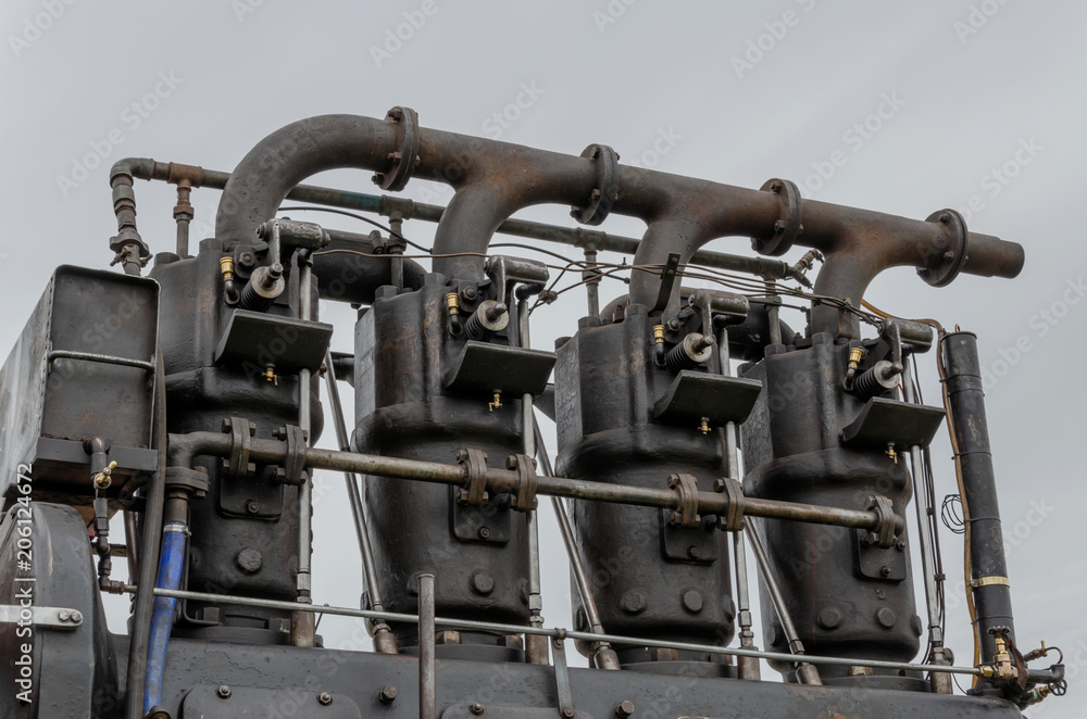 Detail view of a vintage stationary engine. The engine has 4 cylinders ...