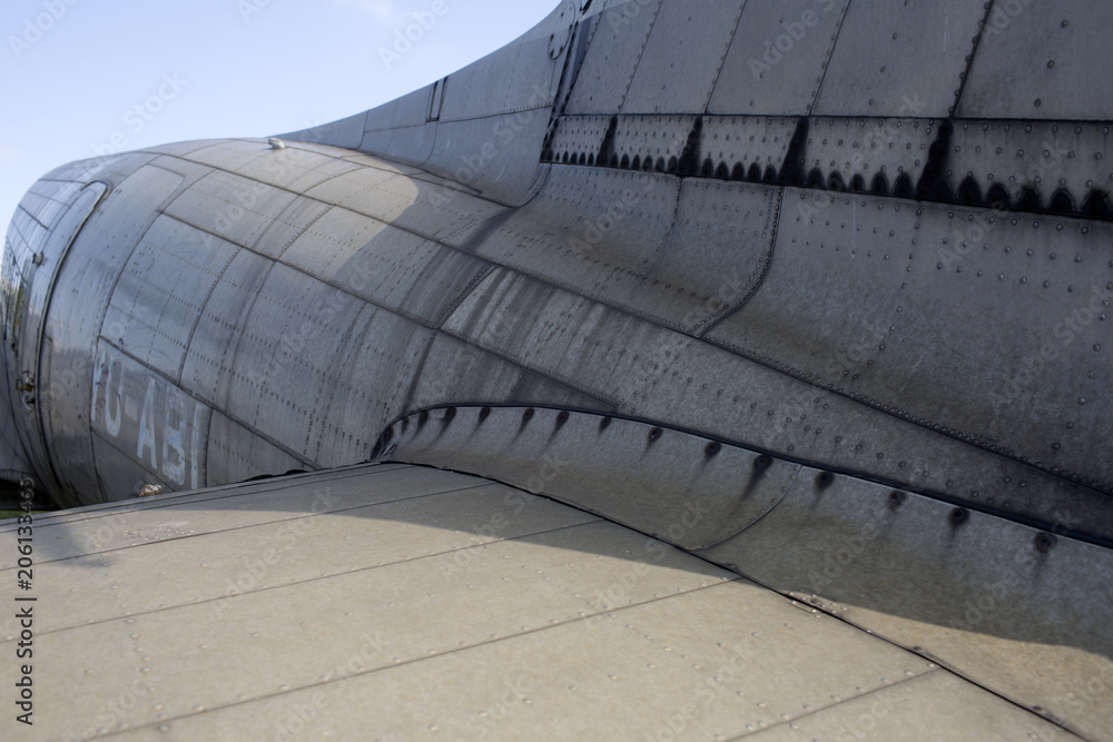 Airplane metallic fuselage detail with rivets. Old silver metal surface ...