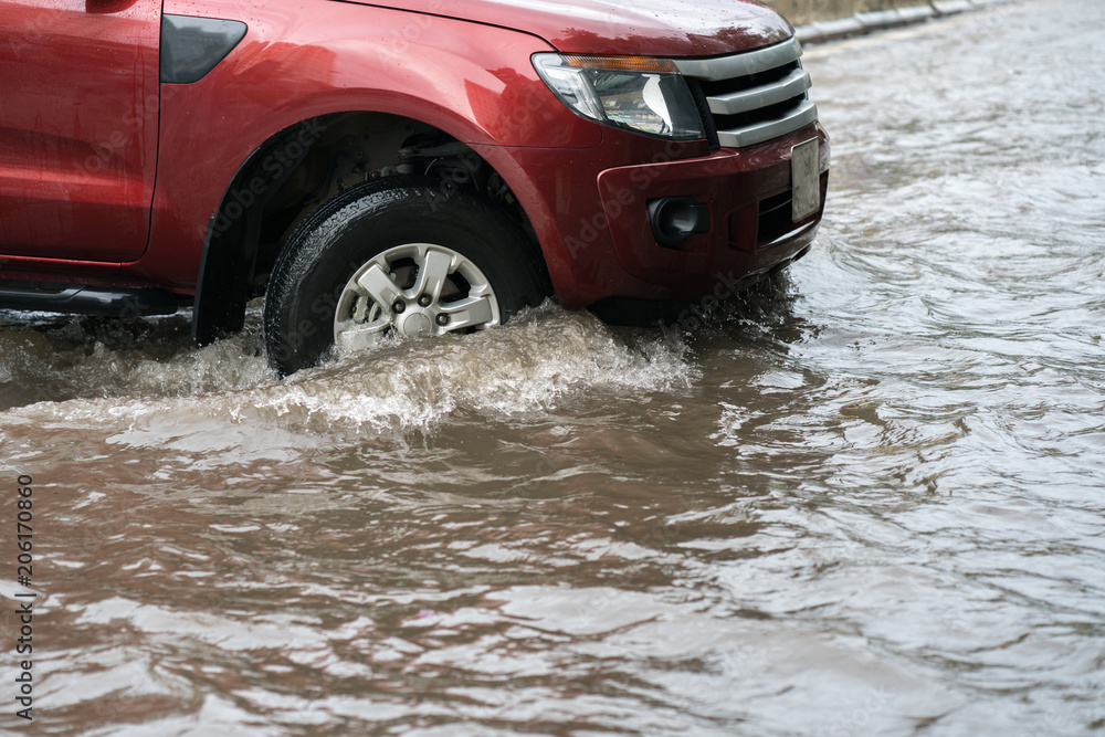 Car splashes through a large puddle on a flooded street Stock Photo ...