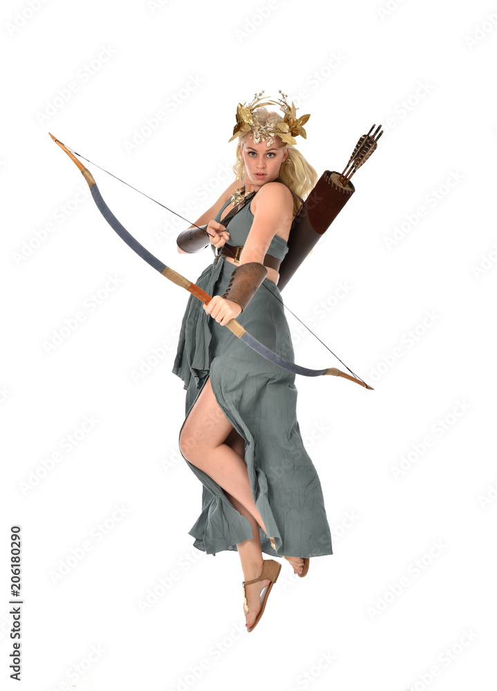 Full Length Portrait Of Pretty Blonde Lady Wearing Fantasy Toga Gown And Holding A Bow And