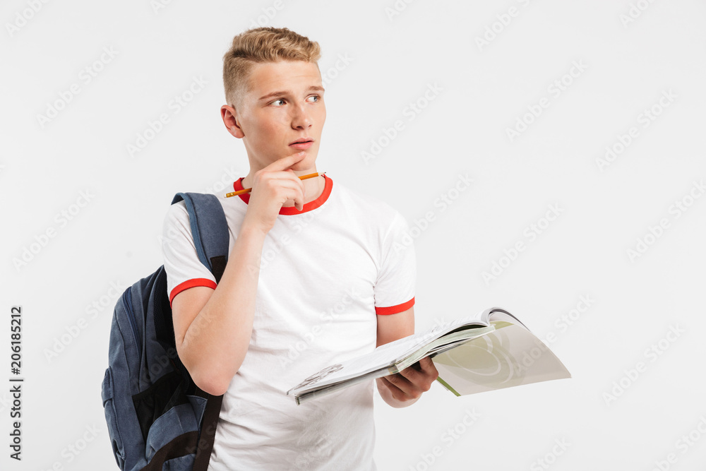 Image of young concentrated male student wearing backpack thinking and ...