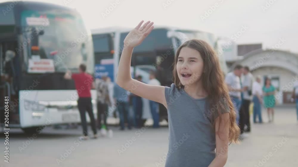 little girl waving her hand at the bus station slow motion video ...