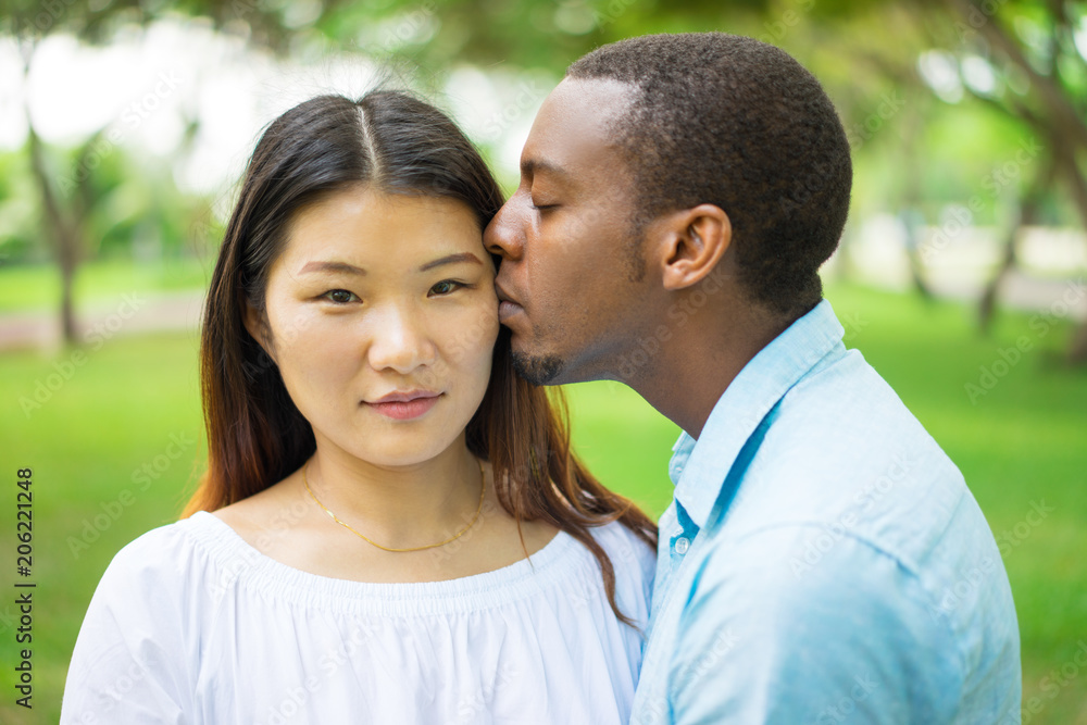 Calm beautiful Chinese girl feeling kiss of boyfriend Stock Photo ...