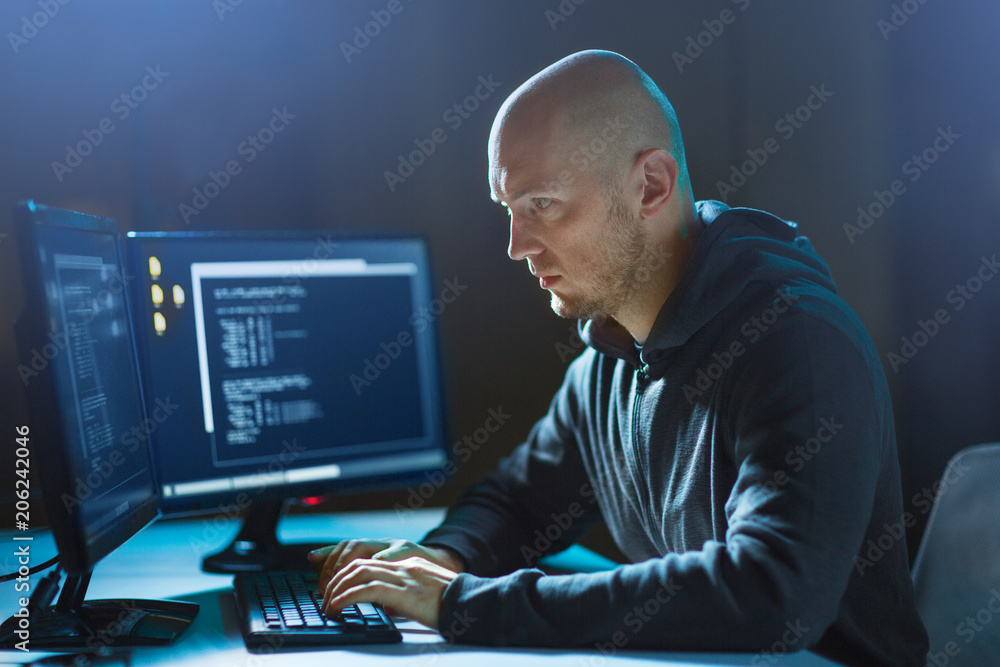 cybercrime, hacking and technology concept - male hacker in dark room ...