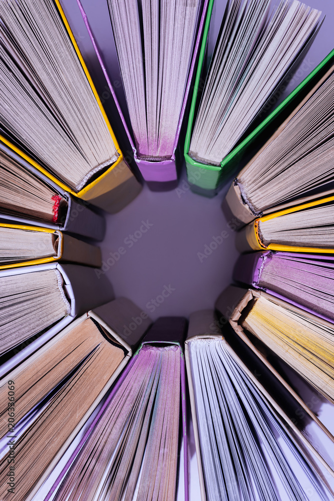 top view of stack of colored books in circle on violet table Stock ...